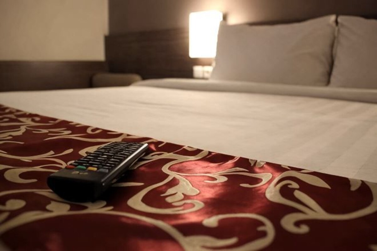Uma cama com um controle remoto ao lado.