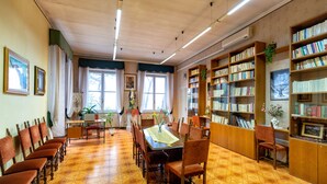 Uma biblioteca com uma mesa comprida e cadeiras, rodeada por estantes de livros.