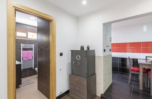 Uma casa de banho moderna com porta-toalhas, porta de madeira e um pequeno armário.