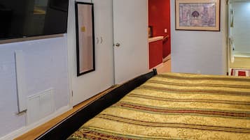 Quarto com cama, guarda-roupa e televisão.
