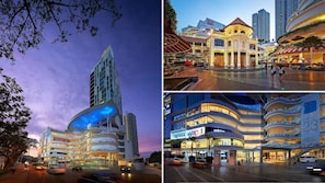 Um hotel moderno com vários andares, fachada curva em vidro e um átrio central.