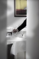 Um garçom colocando um copo em uma mesa em um restaurante.