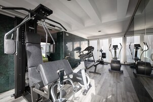 Academia moderna com diversos equipamentos de ginástica, incluindo máquina de pesos, esteiras e bicicletas ergométricas.