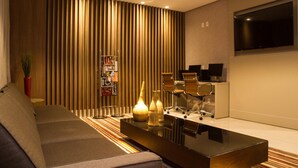 Uma sala de estar moderna com um sofá, uma mesa de centro e uma televisão.