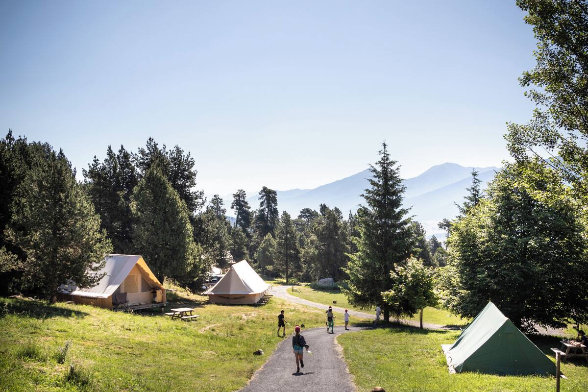 Um camping com várias tendas e uma mesa para piquenique.