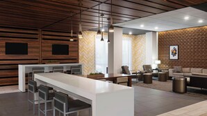Cozinha moderna com ilha central, banquetas e iluminação pendente.