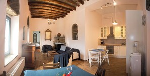 Uma sala de estar aconchegante com lareira, área de jantar e cozinha equipada com eletrodomésticos modernos.