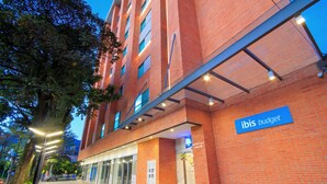 Um edifício de tijolos com uma placa indicando "ibis budget".