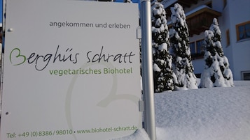Placa de um hotel vegetariano e biológico, com informações de contato e endereço de site.