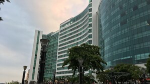 Um hotel moderno com fachada curva, vários andares e fachada de vidro.