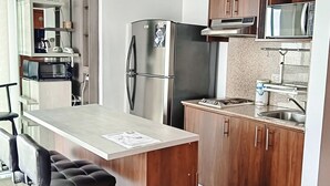 Uma cozinha moderna com ilha central, armários de madeira, eletrodomésticos de aço inoxidável e um banco de bar.