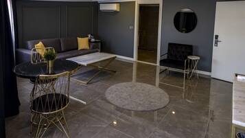 Uma sala de estar moderna com um sofá, uma mesa de centro e um espaço de jantar com mesa e cadeiras.