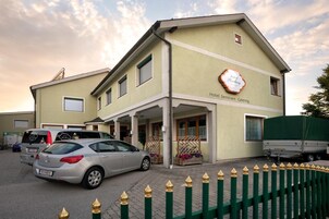 Um edifício com uma placa indicando 'Hotel Seminarie Catering' e um carro estacionado na frente.