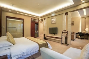 Quarto de hotel com duas camas, televisão, escrivaninha e guarda-roupa.