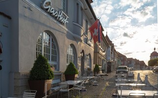 Um edifício com uma placa que diz 'Gasthof' e a bandeira suíça.