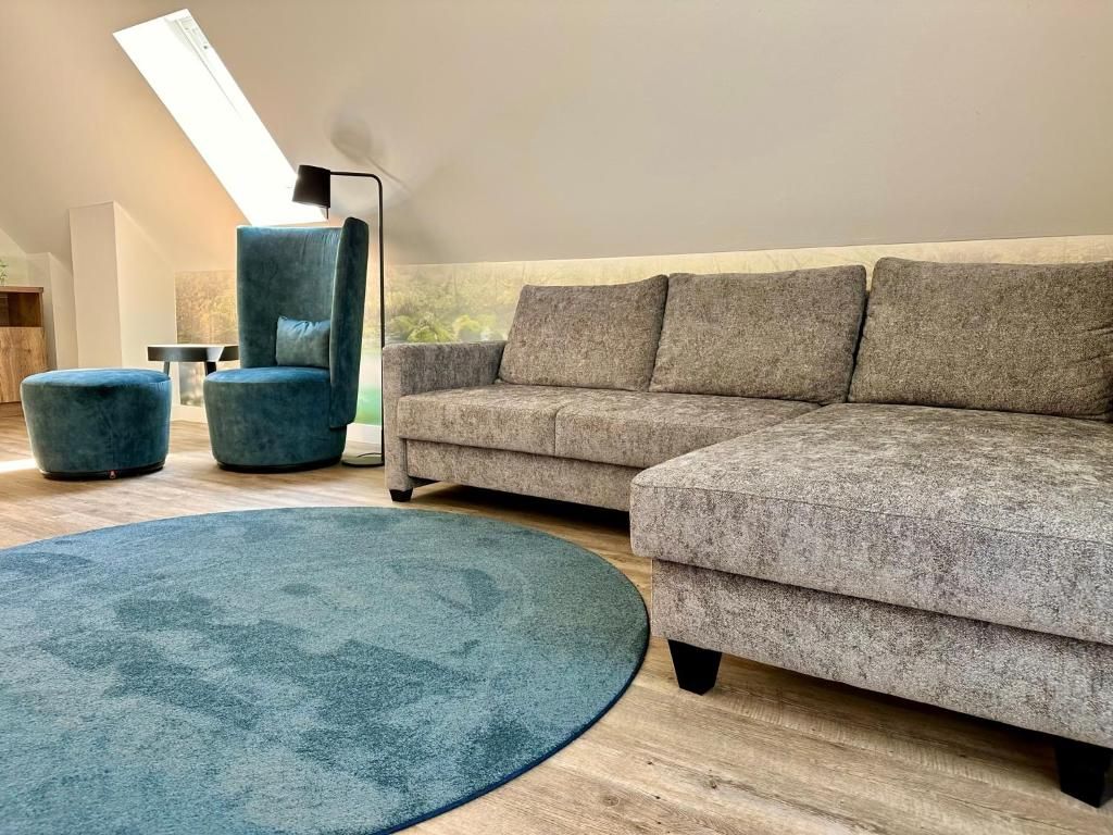 Uma sala de estar moderna com um sofá seccional, um tapete redondo azul e uma cadeira azul alta.
