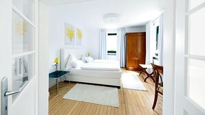 Quarto moderno com cama, mesa de cabeceira e guarda-roupa de madeira.