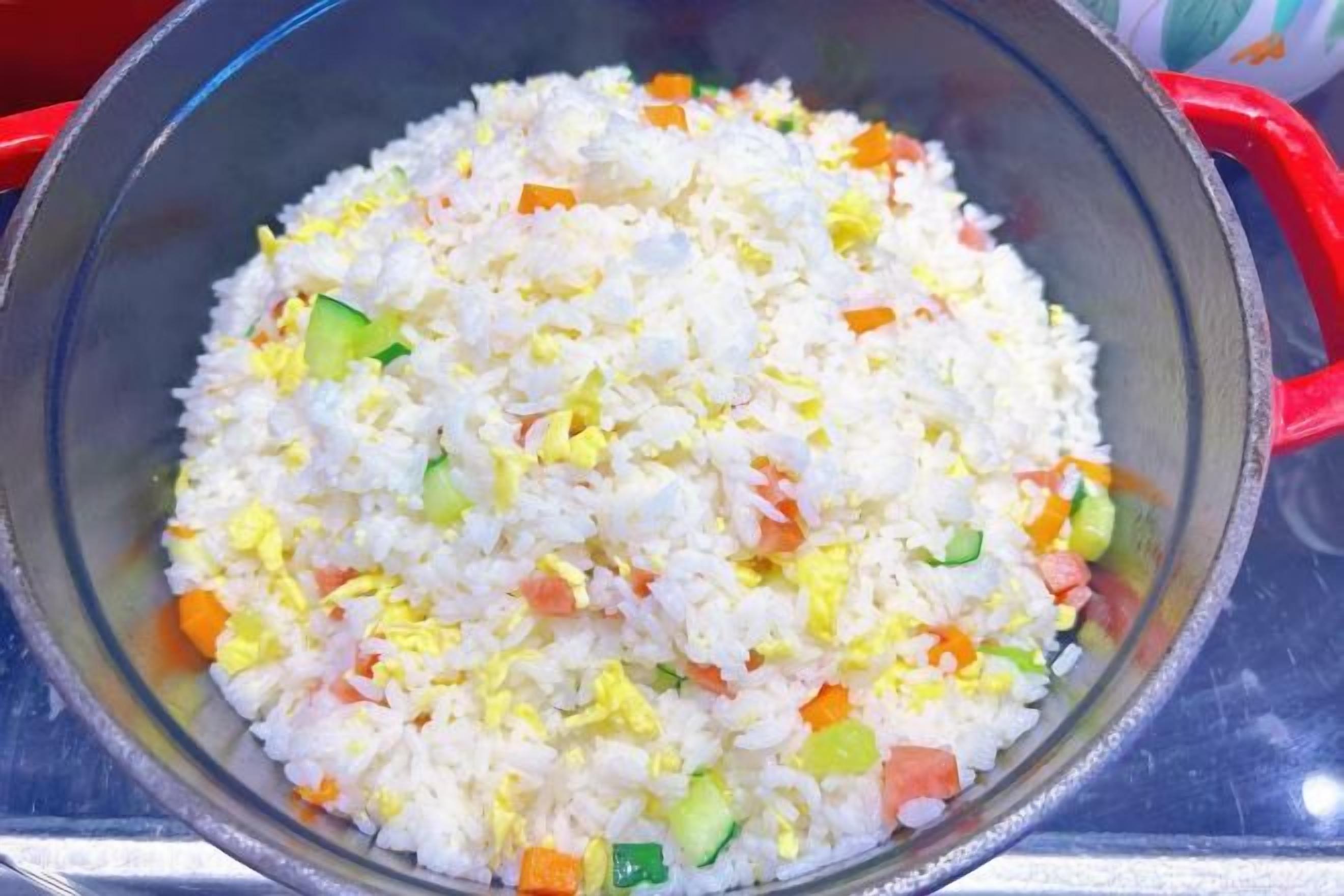 Uma panela de arroz frito com legumes.