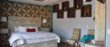 Um quarto moderno com uma cama grande, uma escrivaninha e uma cadeira.