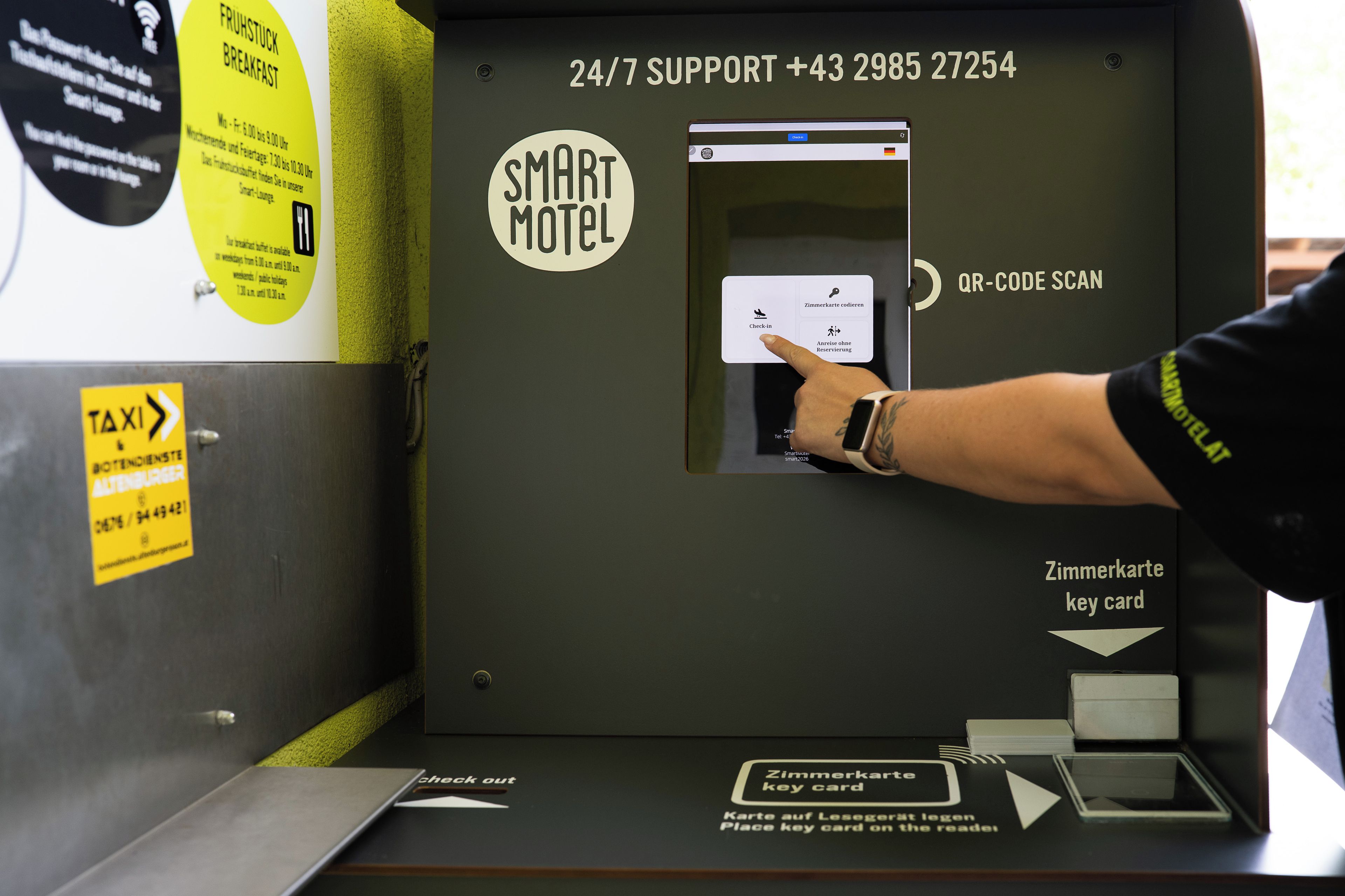 Pessoa utilizando um leitor de código QR em um quiosque de check-in para um hotel inteligente.