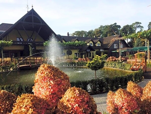 Um hotel com lago, fonte e ponte.