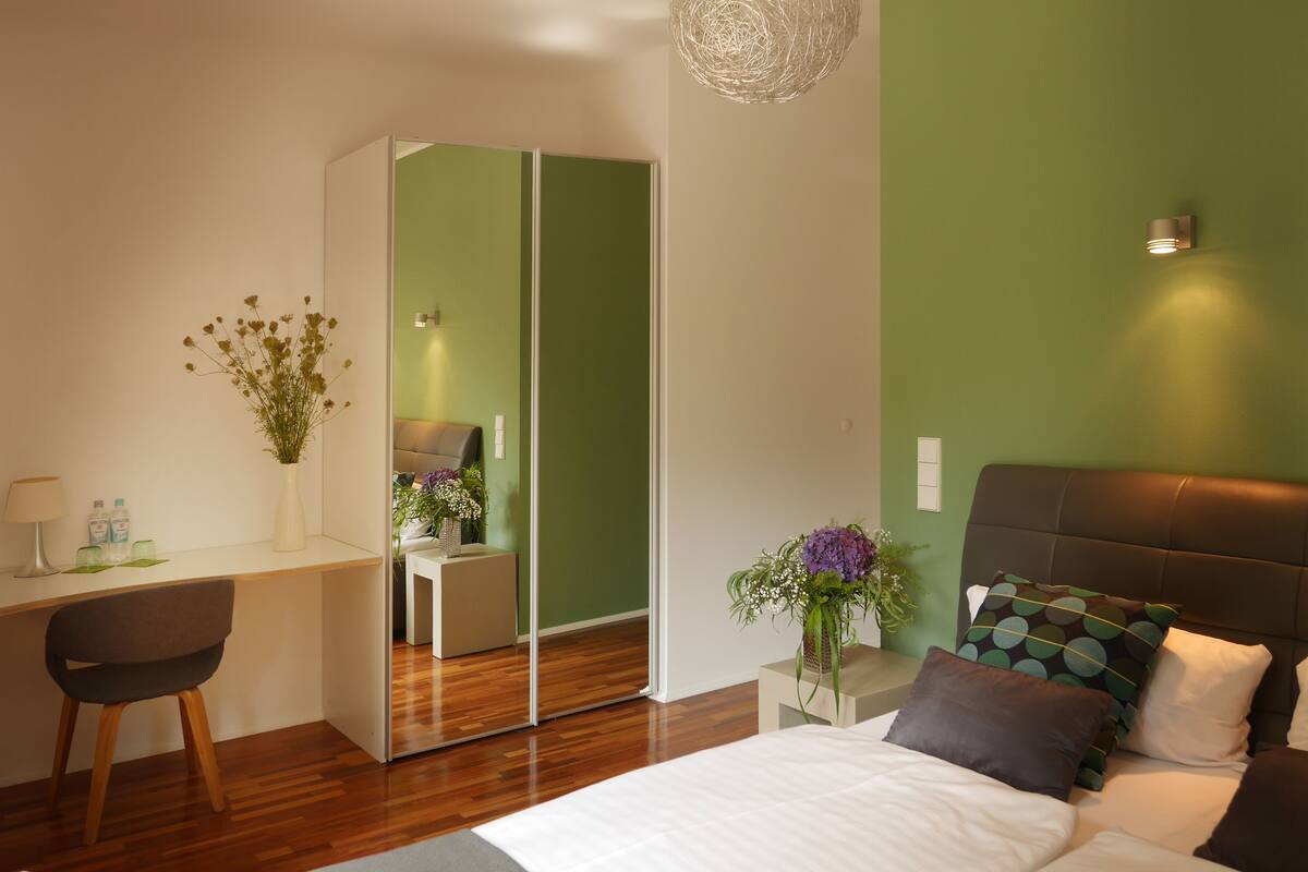 Quarto moderno com uma cama, uma escrivaninha e um espelho.