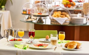 Um buffet de café da manhã com diversas opções de alimentos e bebidas.