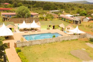 Piscina rodeada por edifícios e uma pequena área ajardinada.