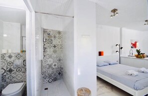 Um banheiro moderno com azulejos estampados, chuveiro e vaso sanitário.