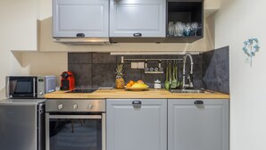 Uma cozinha compacta com eletrodomésticos de aço inoxidável, micro-ondas, torradeira e pia.