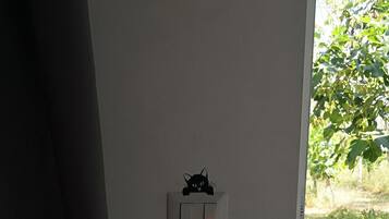 Parede com um interruptor de luz e um adesivo de gato.