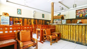Interior de restaurante com mobiliário de madeira, balcão e decorações nas paredes.