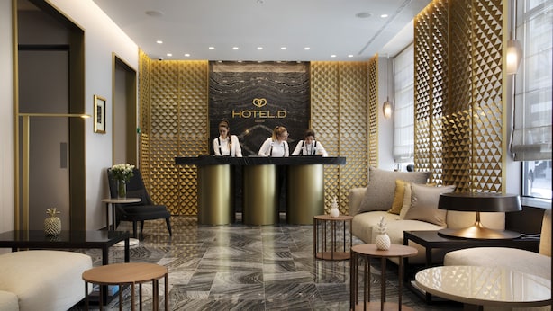 Um lobby de hotel moderno com balcão de recepção, área de estar e painéis decorativos na parede.