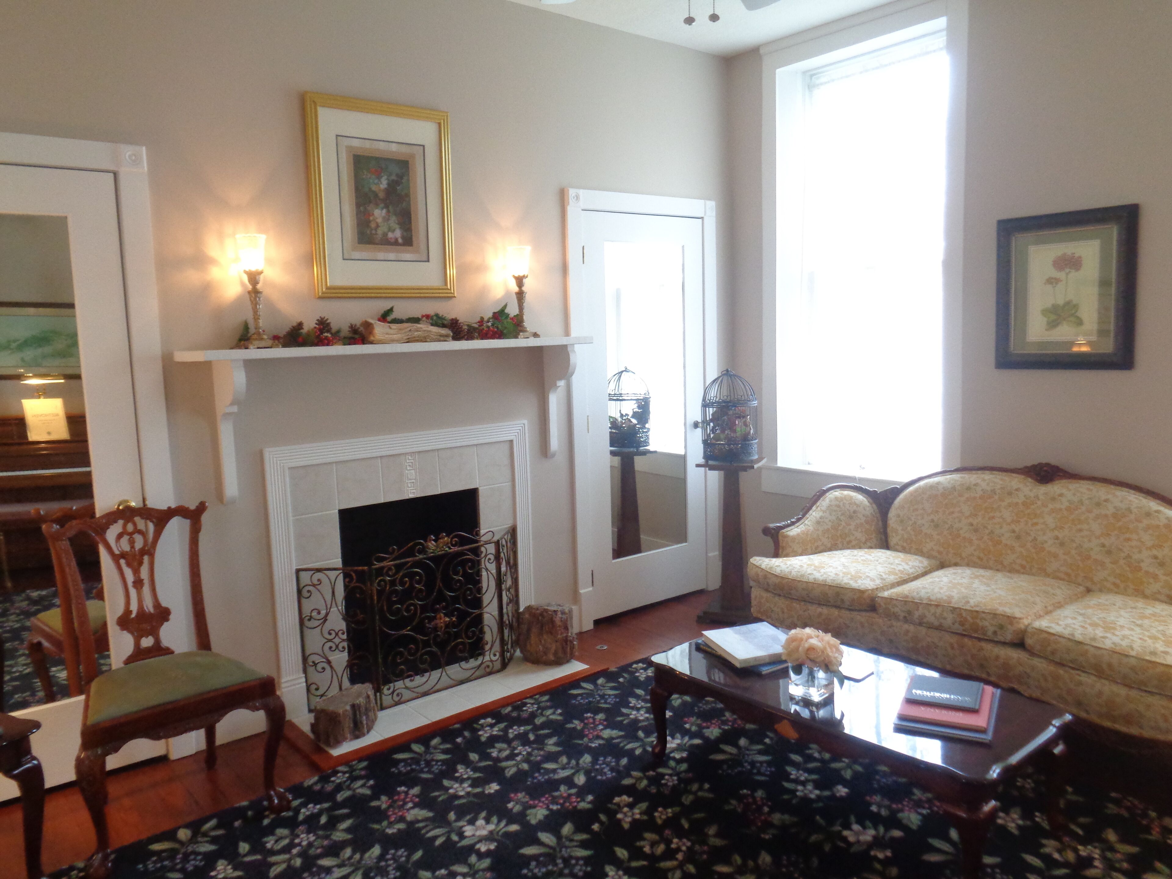 Uma sala de estar com lareira, um sofá, uma poltrona e uma mesa de centro.