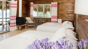 Quarto com duas camas, uma escrivaninha de madeira e uma televisão.