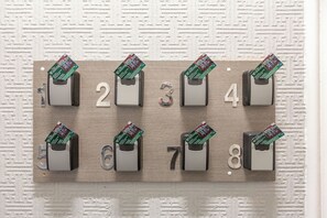 Um painel fixado na parede com espaços numerados, cada um contendo um cartão.