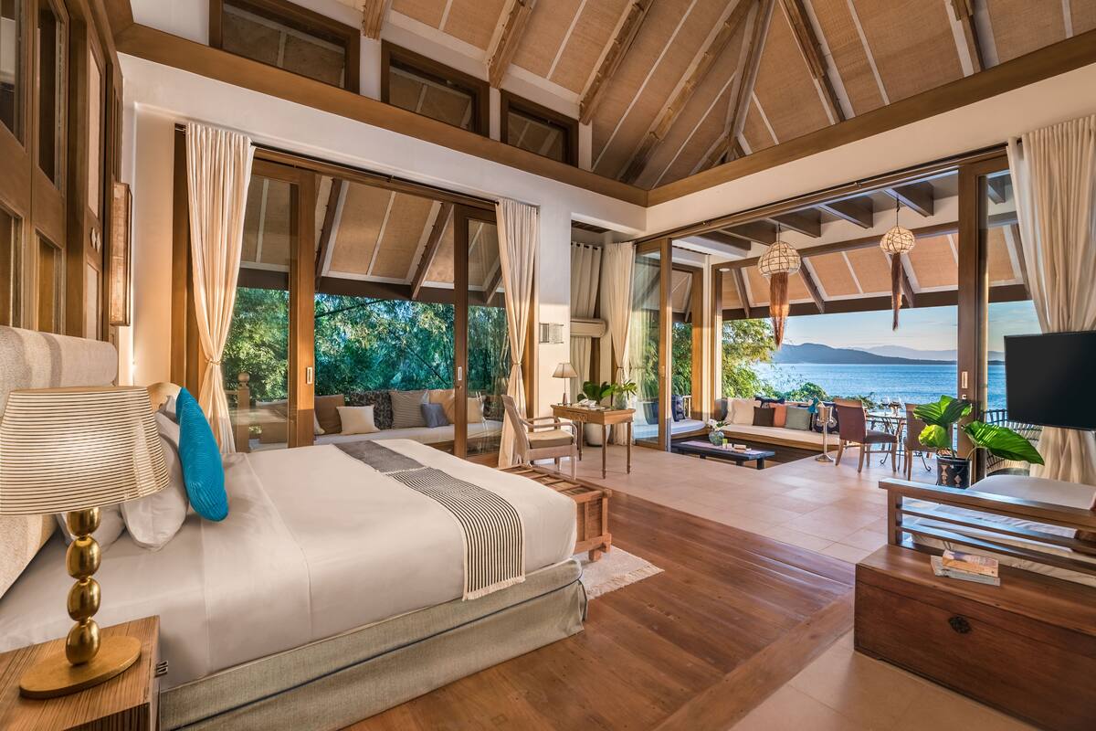 Quarto espaçoso com cama grande, televisão e vista para o mar.