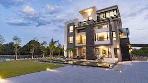 Uma casa moderna de dois andares com piscina, área de estar externa e suporte para bicicletas.