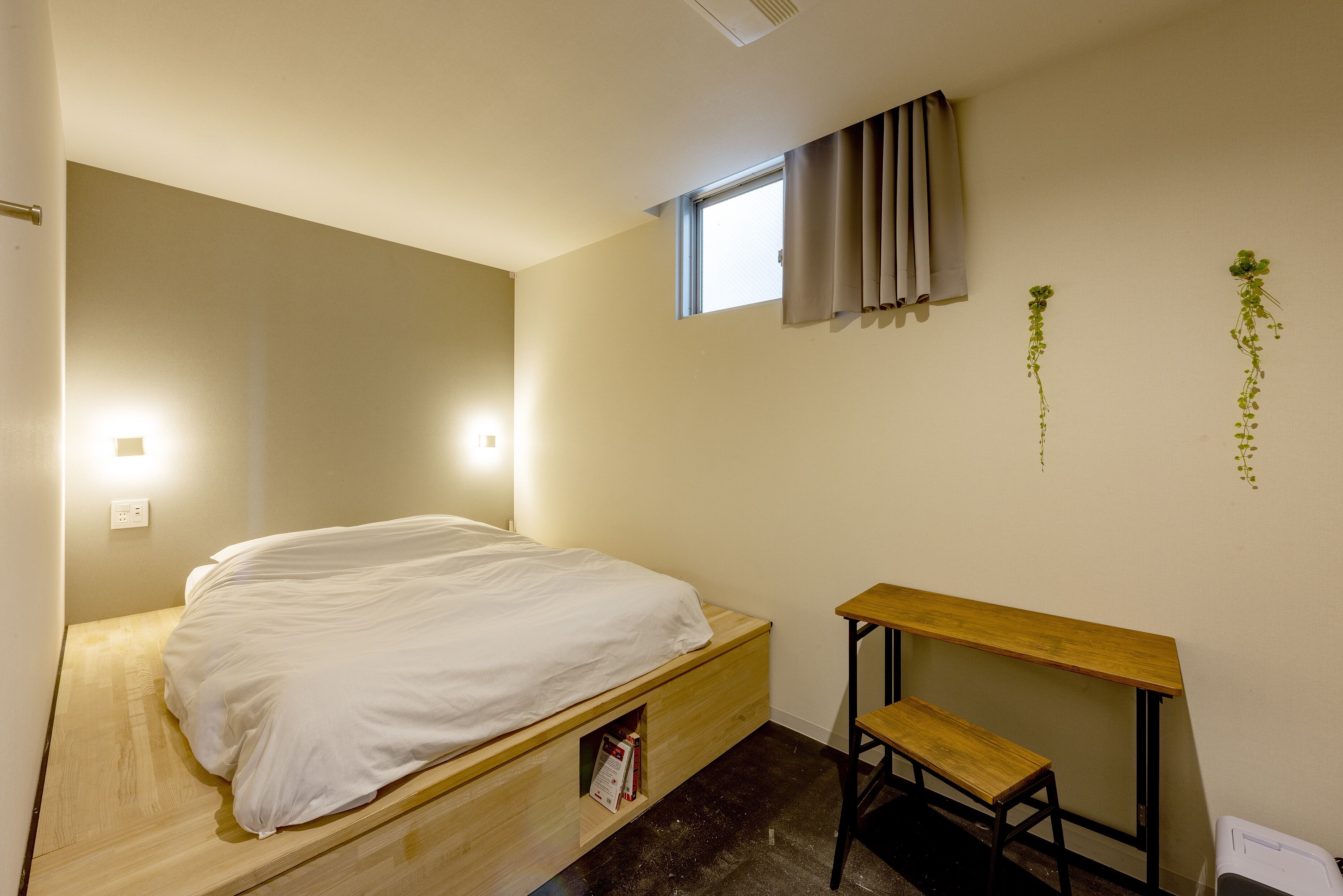 Um quarto pequeno e compacto com uma cama, uma escrivaninha e uma janela.