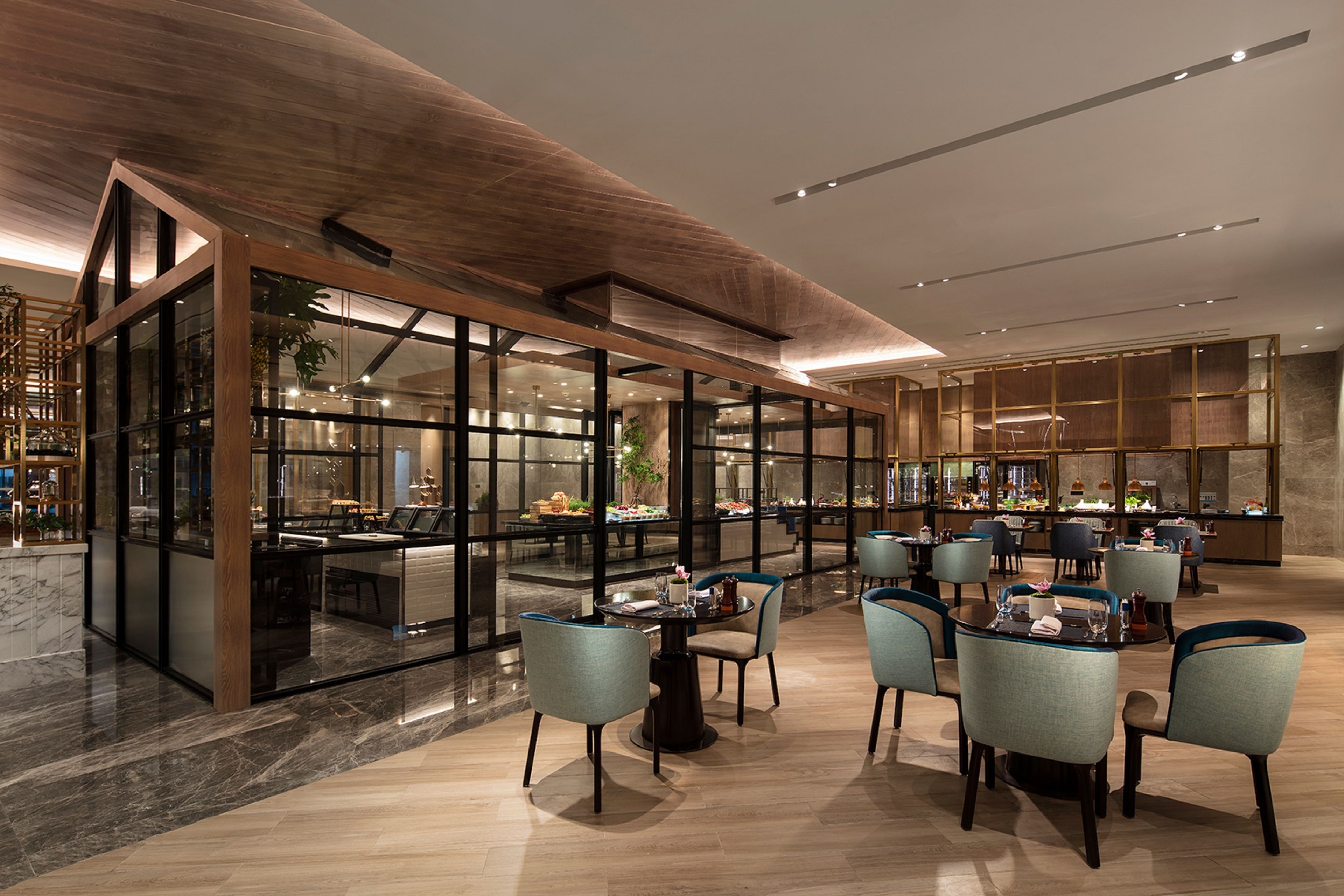 Uma sala de jantar moderna com divisórias de vidro, assentos confortáveis e ambiente bem iluminado.
