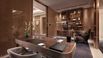 Um espaço de escritório moderno com uma mesa curva, duas cadeiras, uma estante e um vaso decorativo.