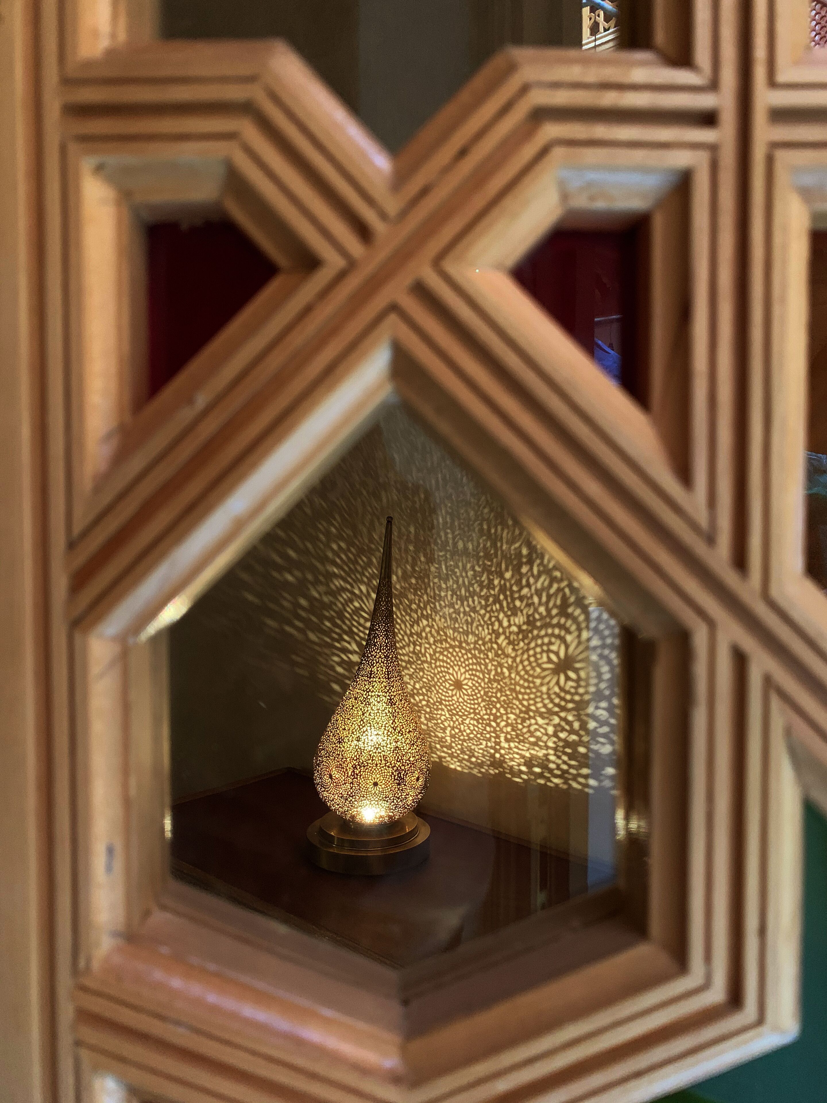 Uma luminária decorativa com estrutura geométrica e padrões elaborados.