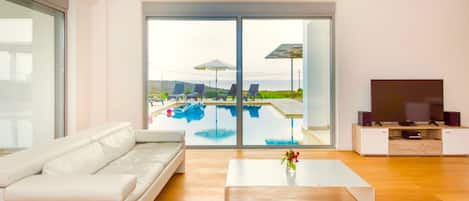 Vila superluxo, 3 quartos, piscina particular, vista para o mar | Área de estar | TV de tela plana 32 polegadas com canais via satélite, TV