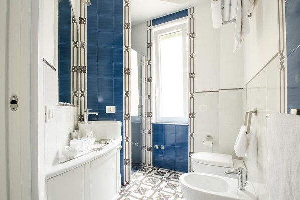 Casa de banho moderna com lavatório branco, sanita e zona de duche.