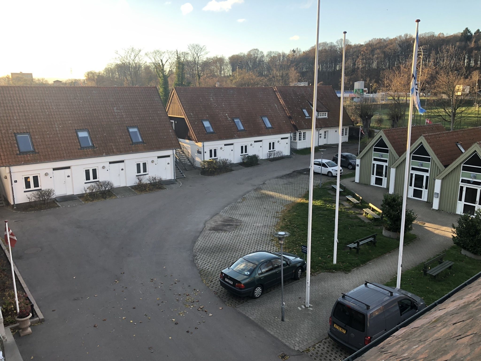 Uma área residencial com várias casas, estacionamento e um mastro com bandeira.