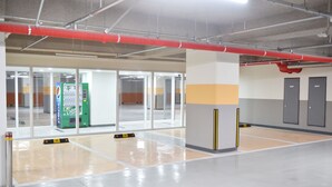 Um espaço amplo e interno, com máquina de vendas automática, portas de vidro e chão limpo.