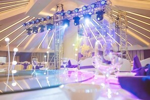 Um palco com equipamentos de iluminação e um arranjo floral.