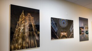 Três obras de arte emolduradas numa parede.