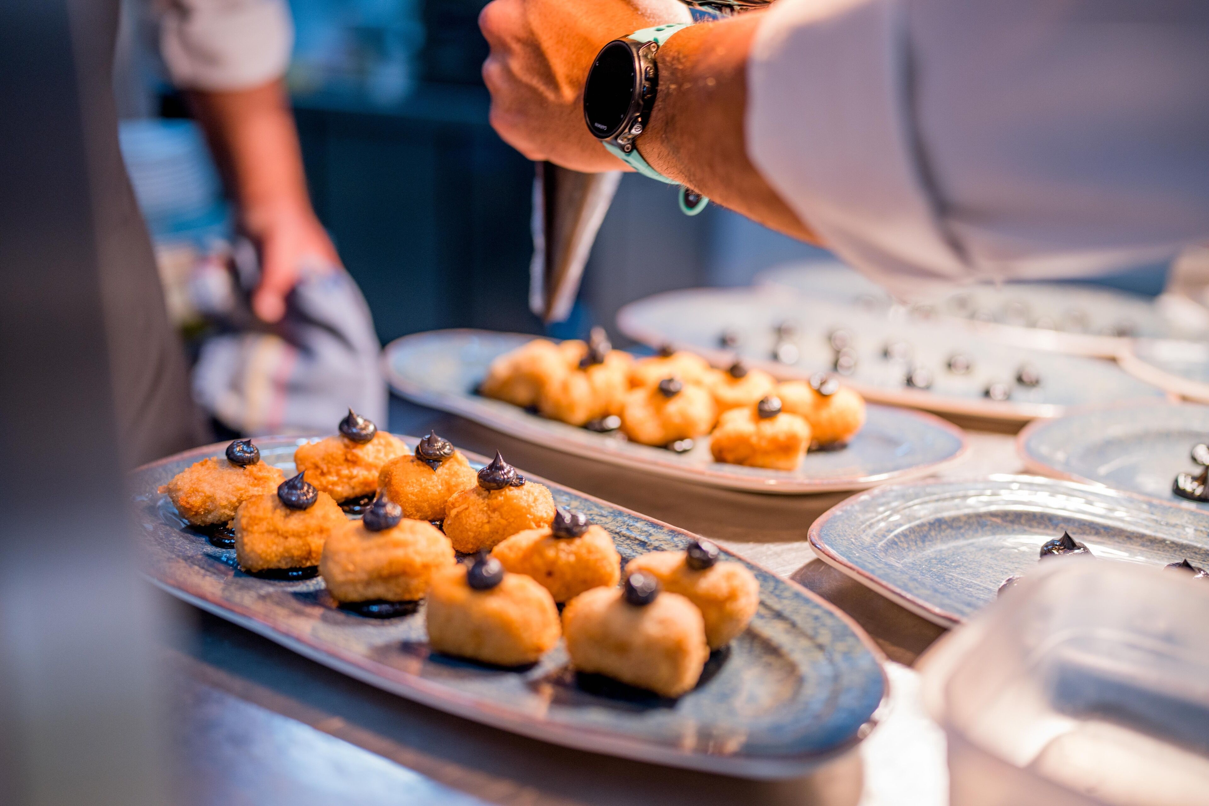 Uma mesa de buffet com diversos pratos, incluindo alguns com cobertura de chocolate.
