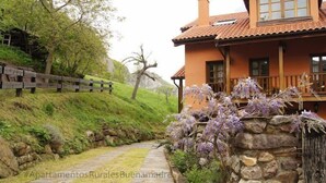 Uma casa rústica com um caminho de pedra que leva a uma cerca de madeira.